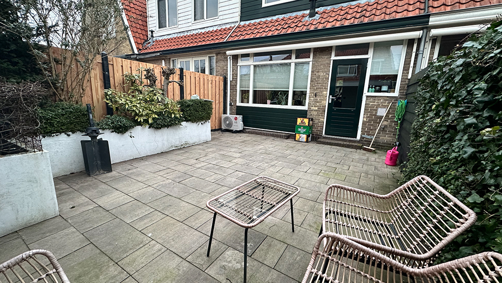 Een kindvriendelijke tuin met een strandgevoel en een buitenkeuken